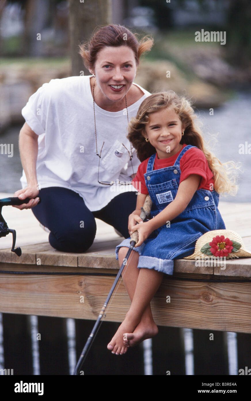 Mother teaching daughter how to fish, fishing trip, laughing, having ...