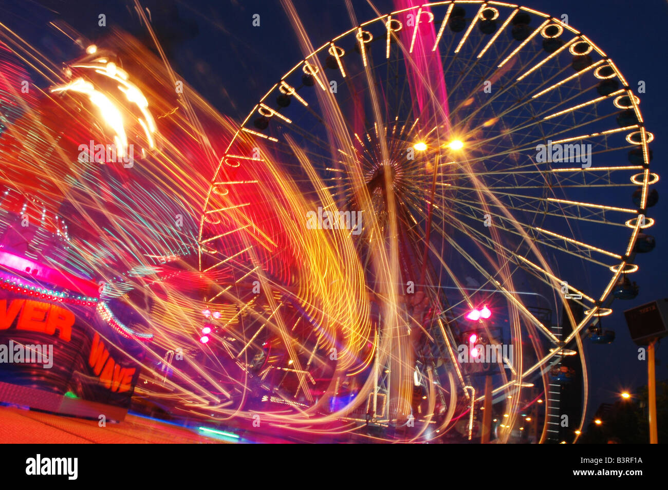 colourful fairground with ferris wheel at dusk Stock Photo - Alamy
