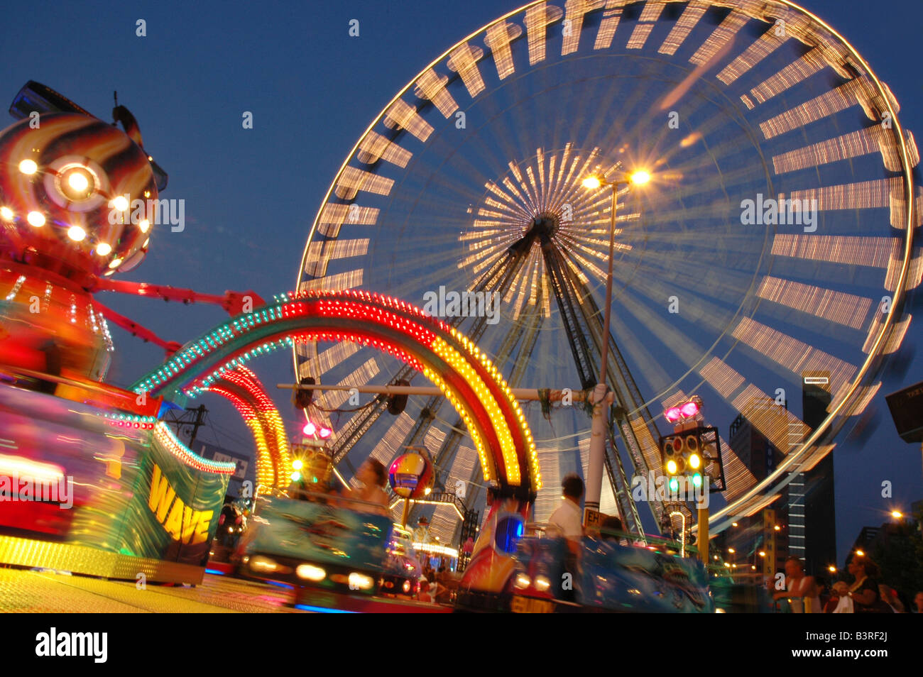 colourful fairground with ferris wheel at dusk Stock Photo - Alamy