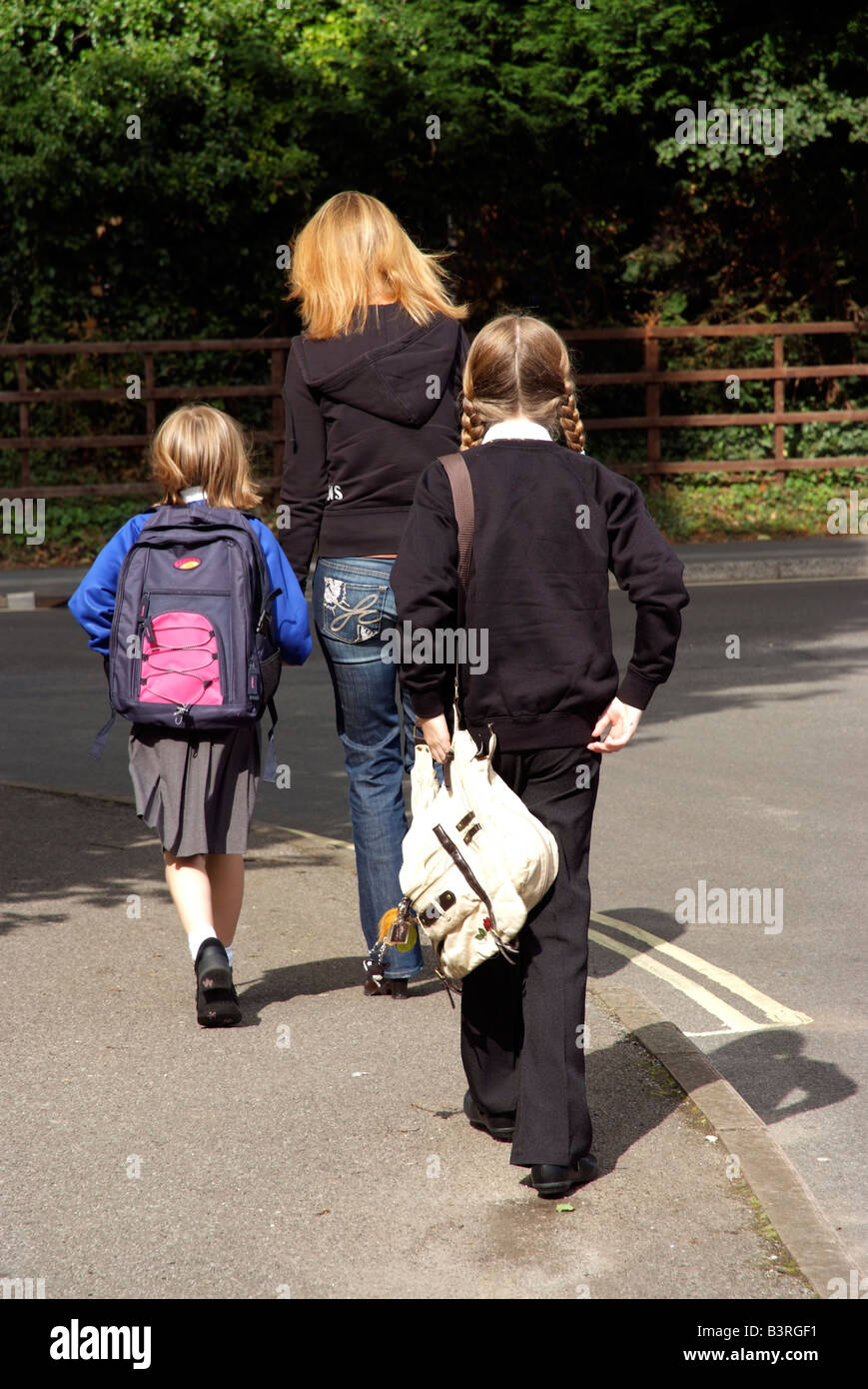 Mother and children walking to school along a pavement Stock Photo ...