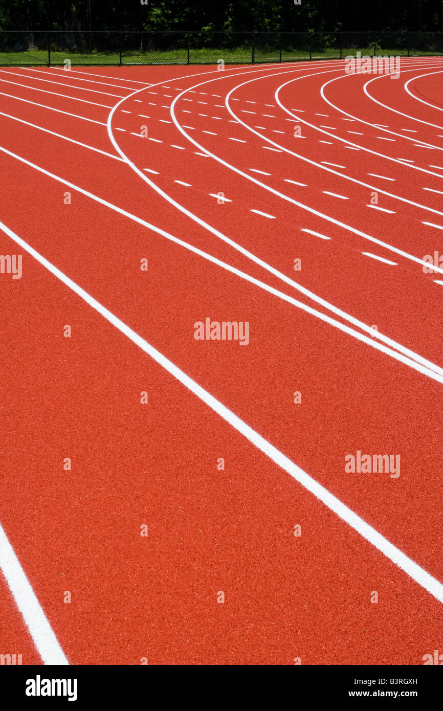 Red orange running track with white straight and curving lane lines ...