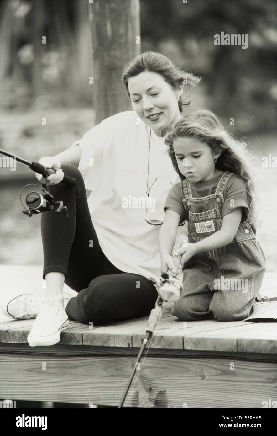 Mother teaching daughter how to fish, fishing trip, laughing, having ...