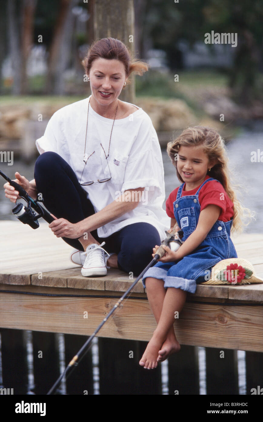 Mother teaching daughter how to fish, fishing trip, laughing, having ...