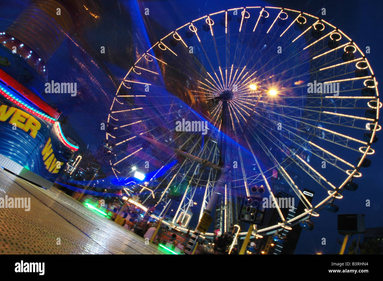 colourful fairground with ferris wheel at dusk Stock Photo - Alamy