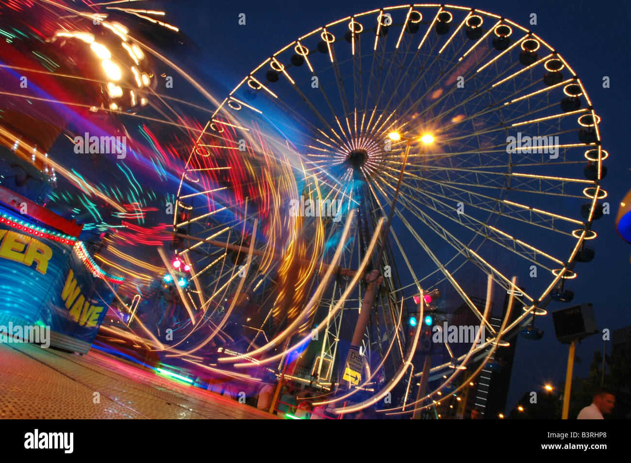 colourful fairground with ferris wheel at dusk Stock Photo - Alamy