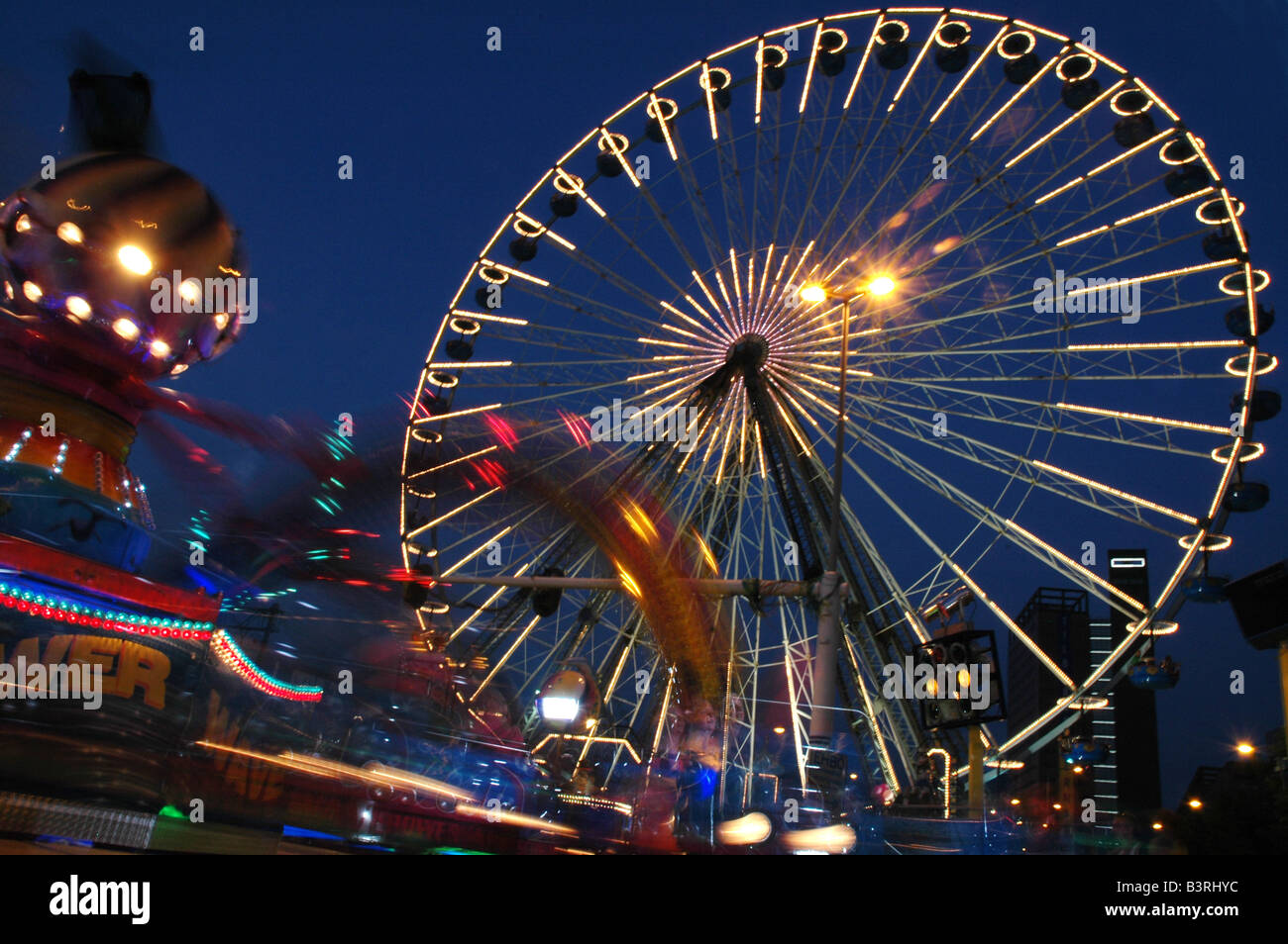 colourful fairground with ferris wheel at dusk Stock Photo - Alamy
