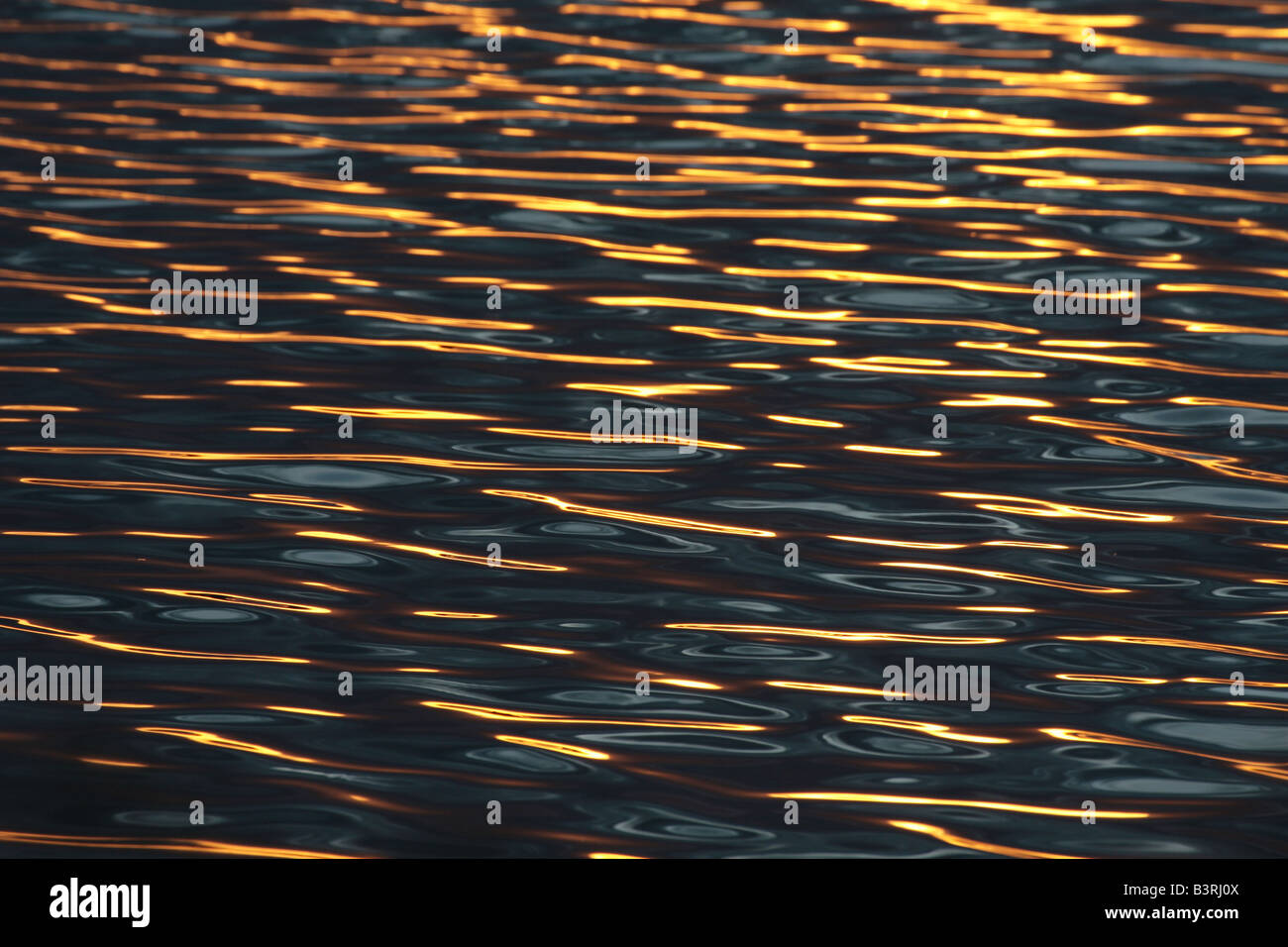 Ripples on water at sunset Stock Photo - Alamy