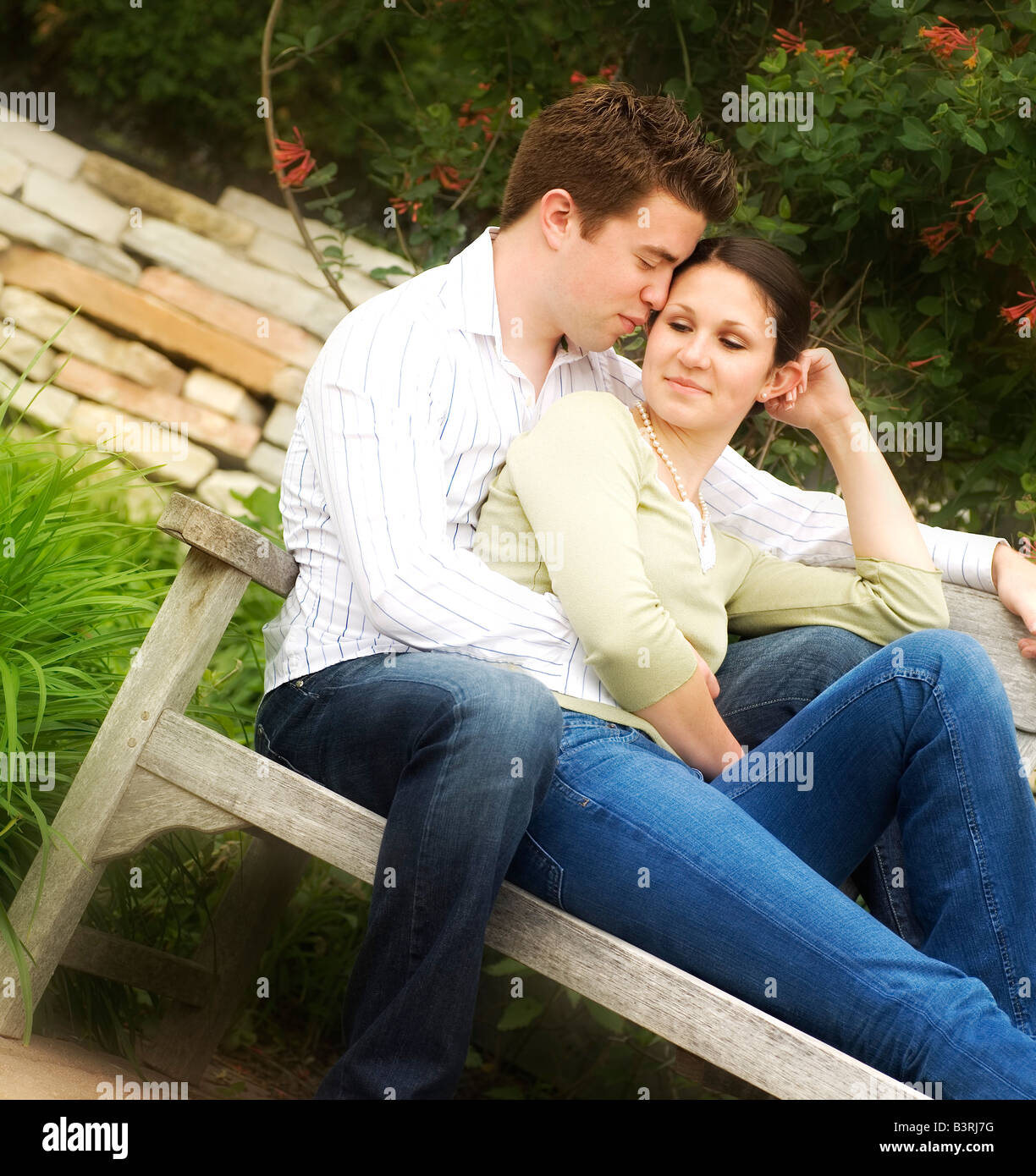 Couple sitting on a bench Stock Photo - Alamy