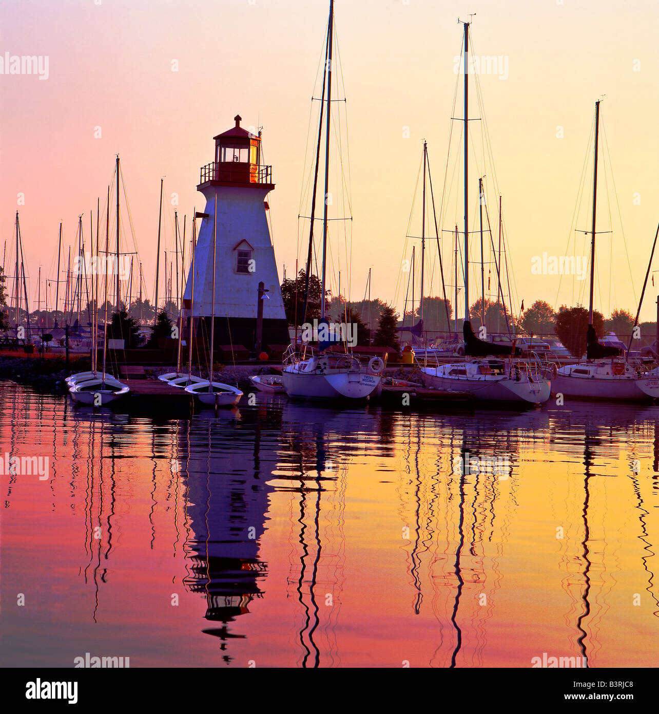 Lighthouse and sailboats Stock Photo - Alamy