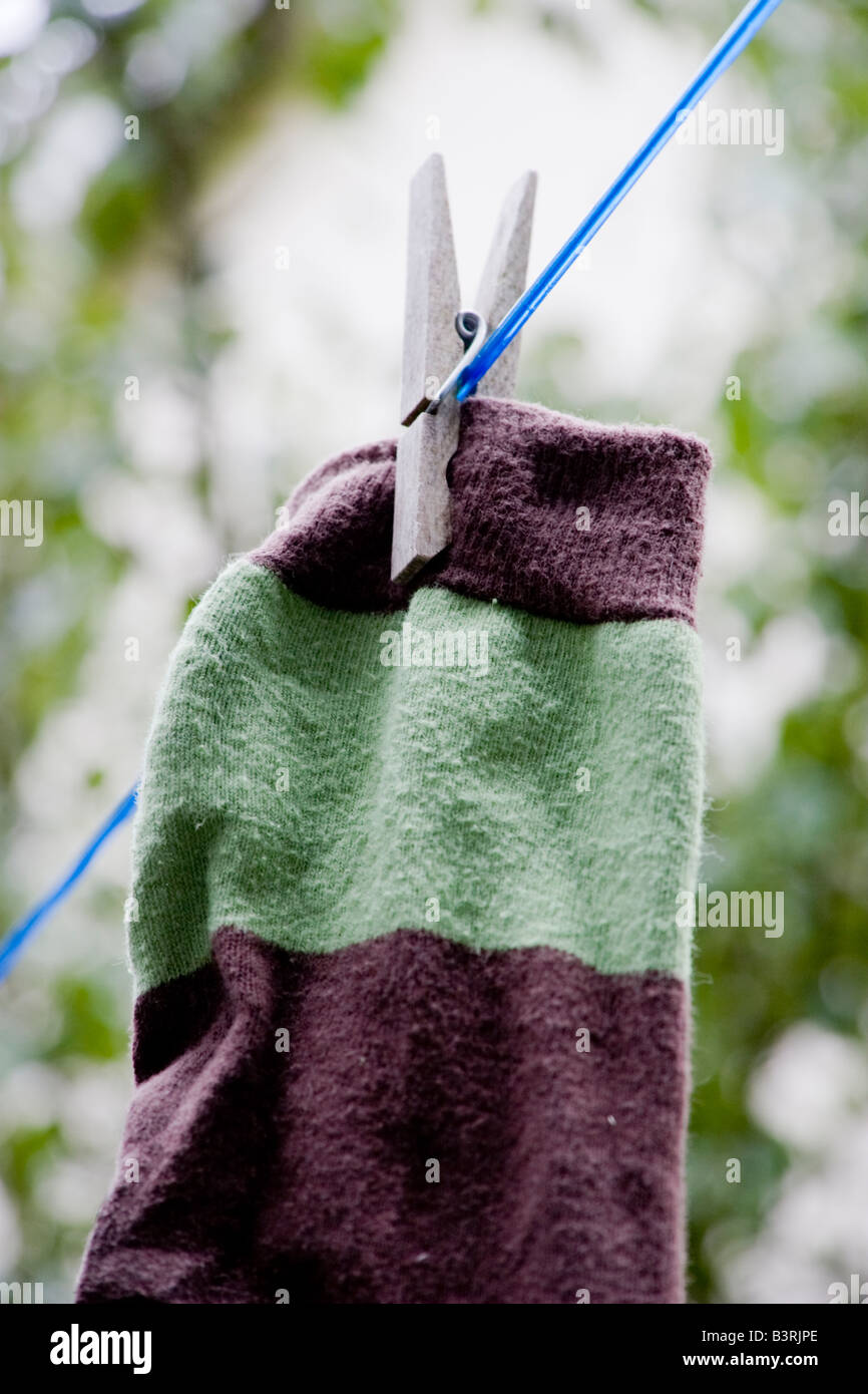 A sock drying on a washing line and held by a wooden peg Stock Photo ...