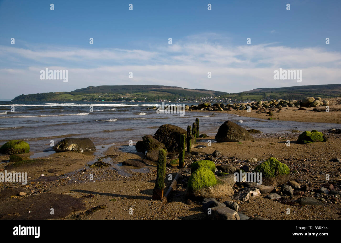Rocks covered in seaweed on Brodick beach on the Isle of Arran in south ...