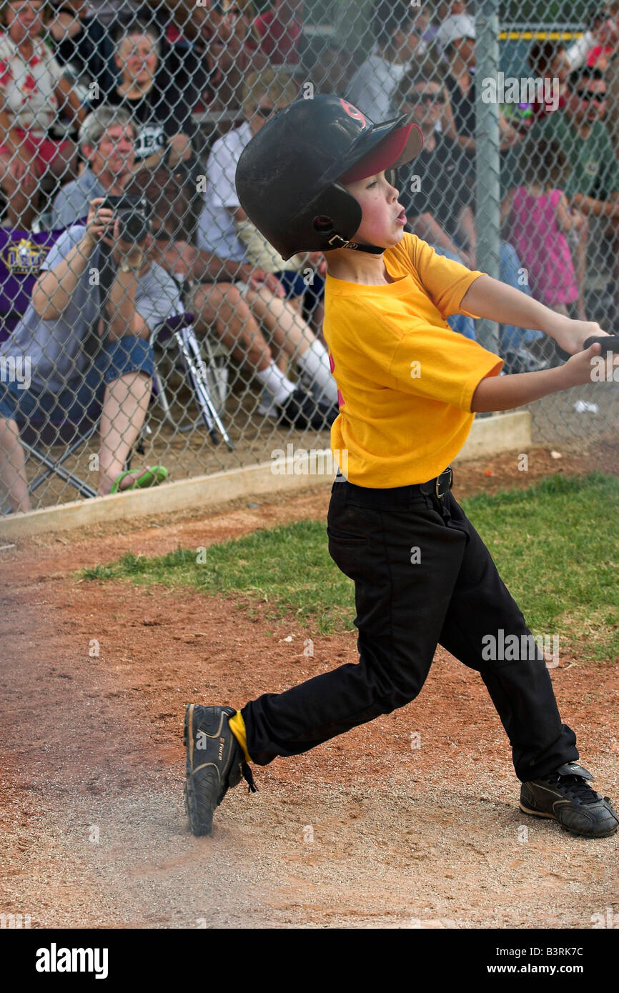 A youngster connects with the baseball in coach-pitch little league ...