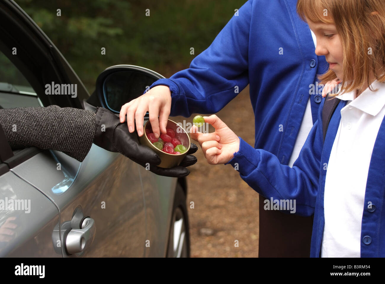 Young girls alone on a country lane taking sweets from a stranger ...