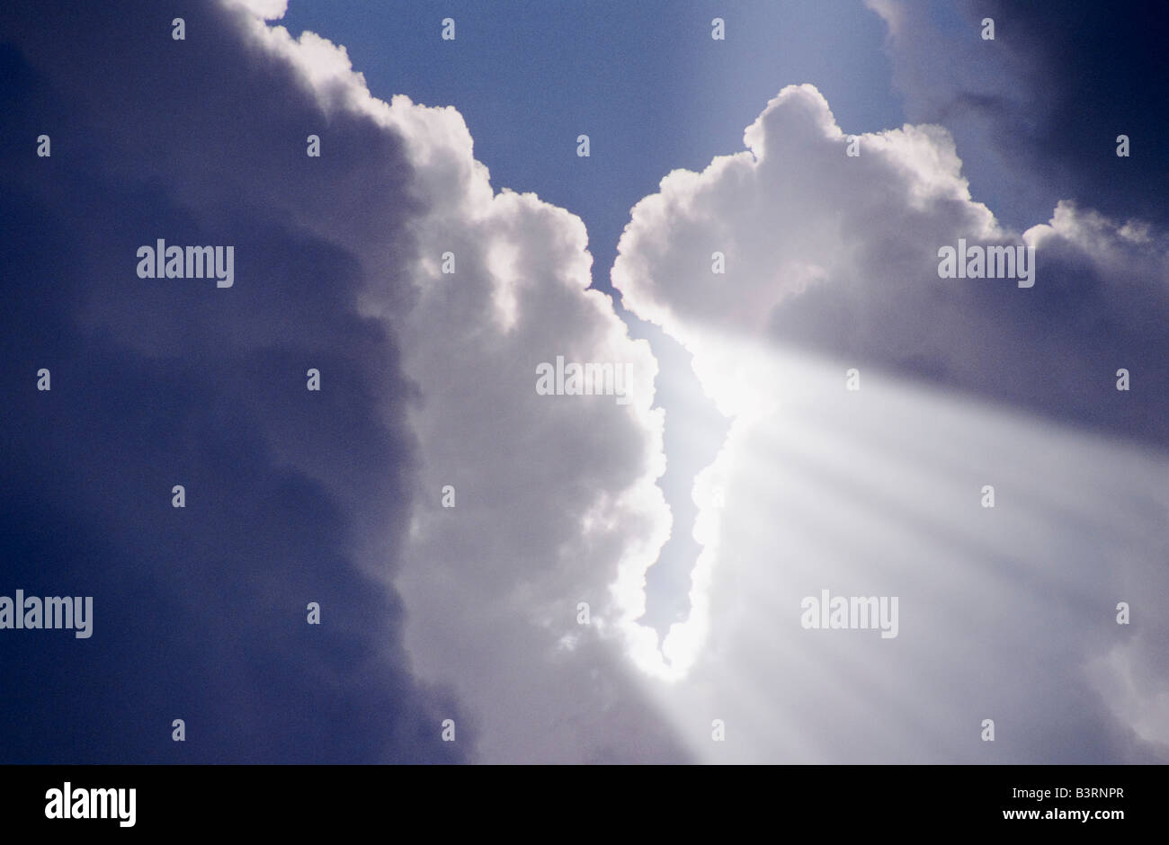 Beams of Light coming through hole in clouds Stock Photo - Alamy