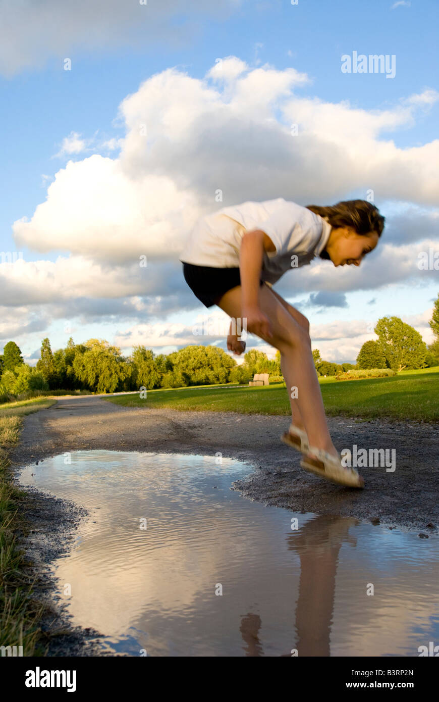 child girl jumping over puddle Stock Photo - Alamy
