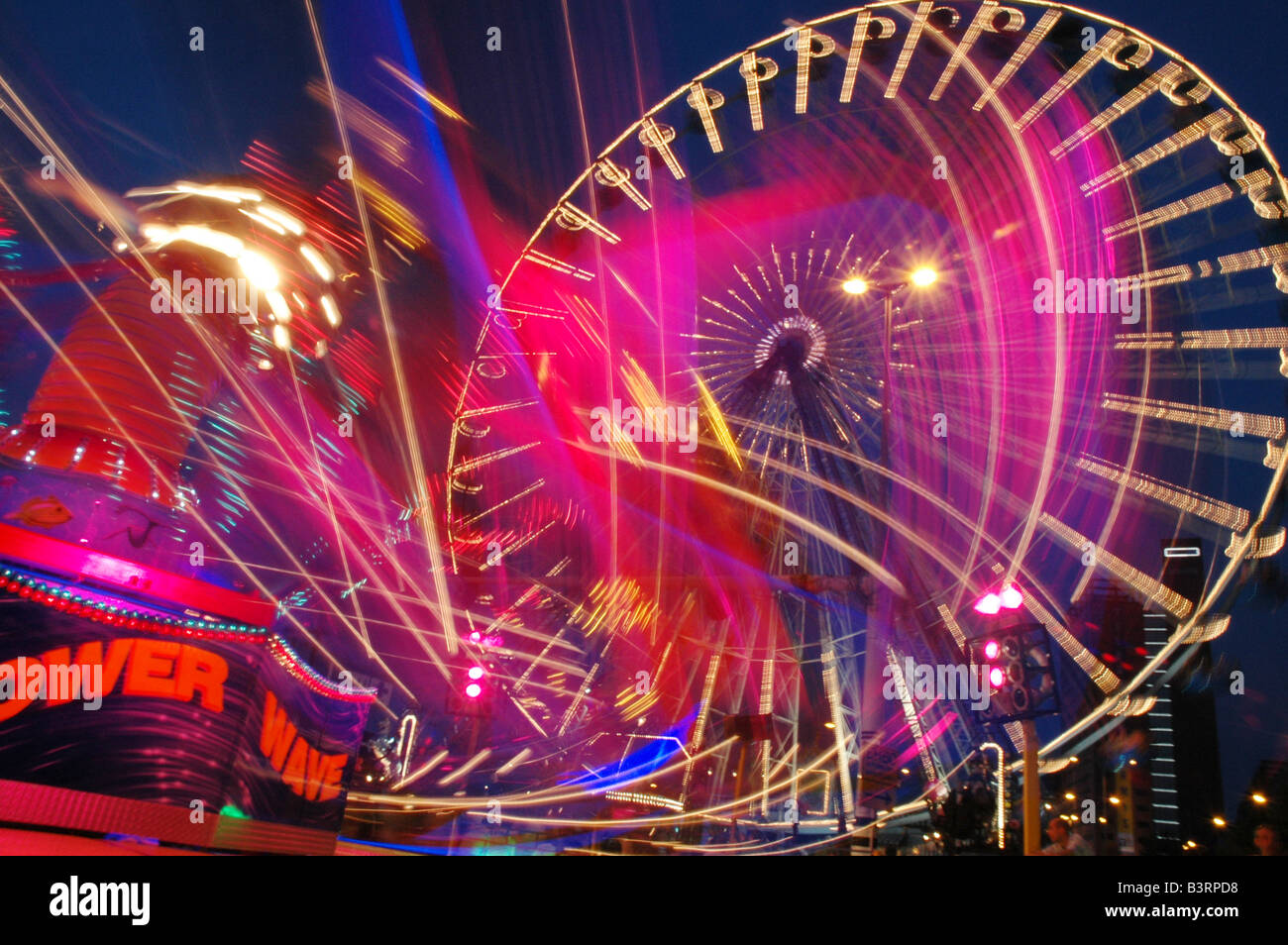 colourful fairground with ferris wheel at dusk Stock Photo - Alamy