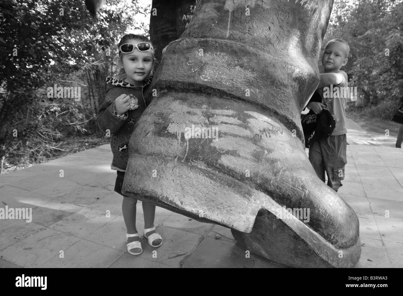 Children play round the feet of the giant statue of Lenin demoted from ...