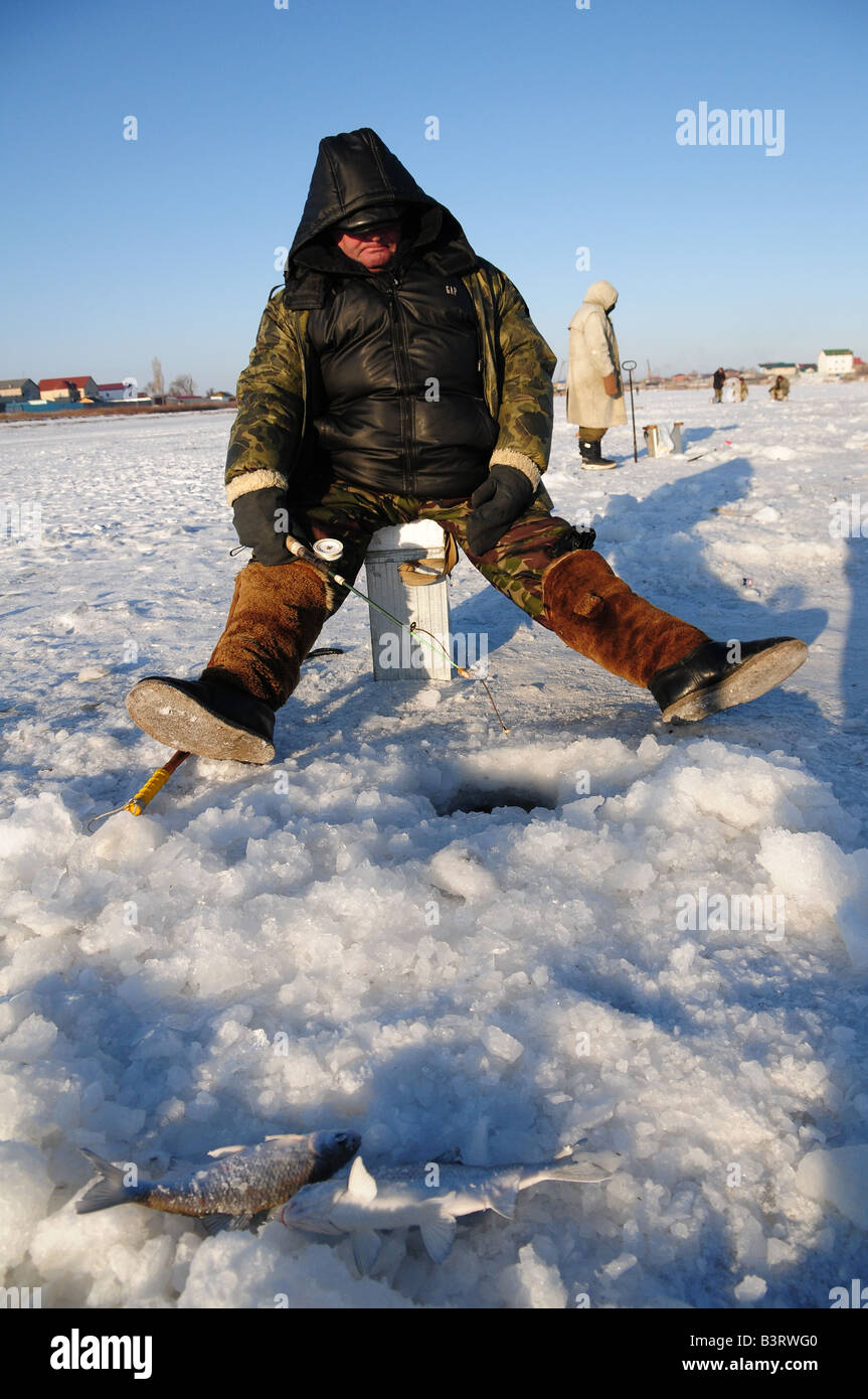Winter fishermen enjoy the minus 25 degrees on the river Ural Stock ...