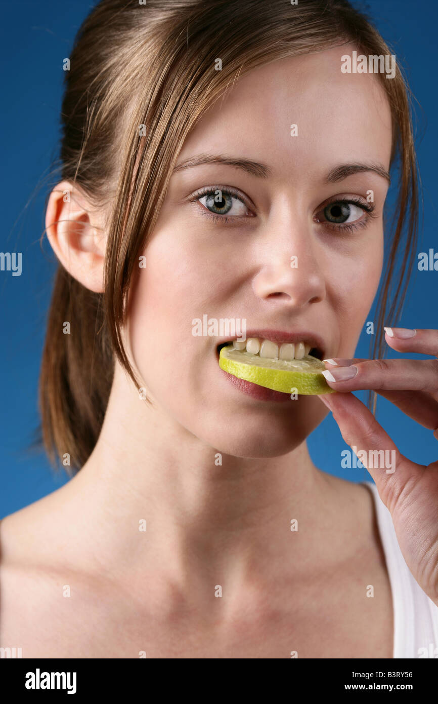 20s female eating a lemon Stock Photo - Alamy