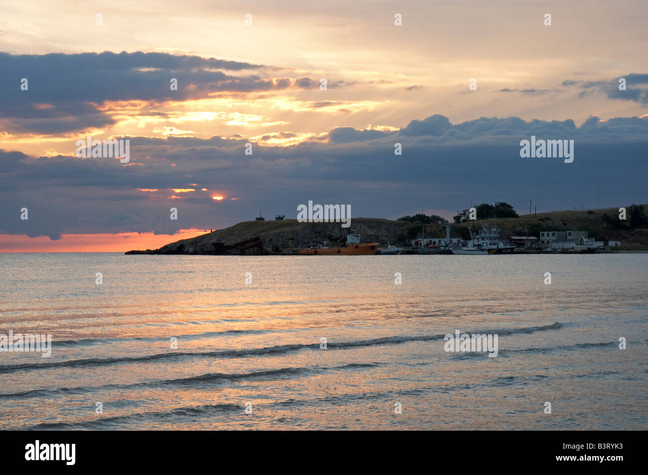 Sea sunset with cape and ships Stock Photo - Alamy
