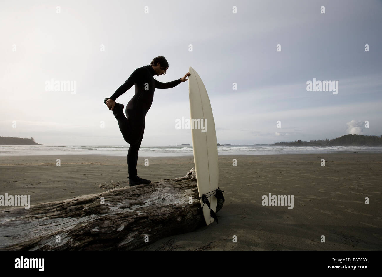 Surfer stretching on beach Stock Photo - Alamy