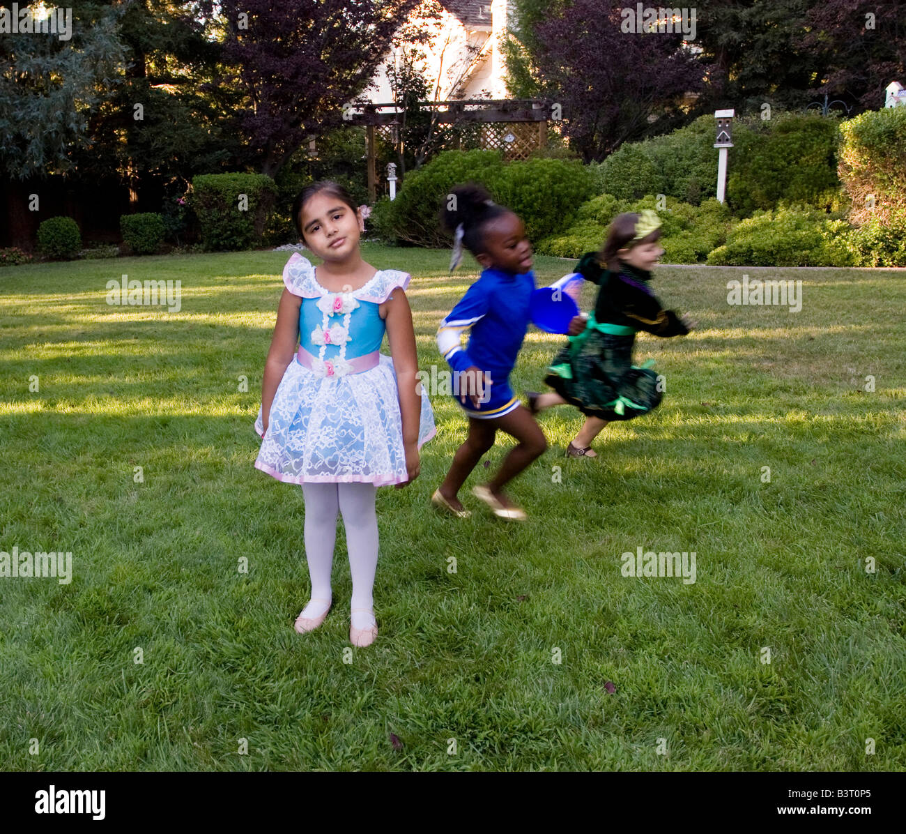 Little girls dressed in Halloween costumes run around the yard Stock ...
