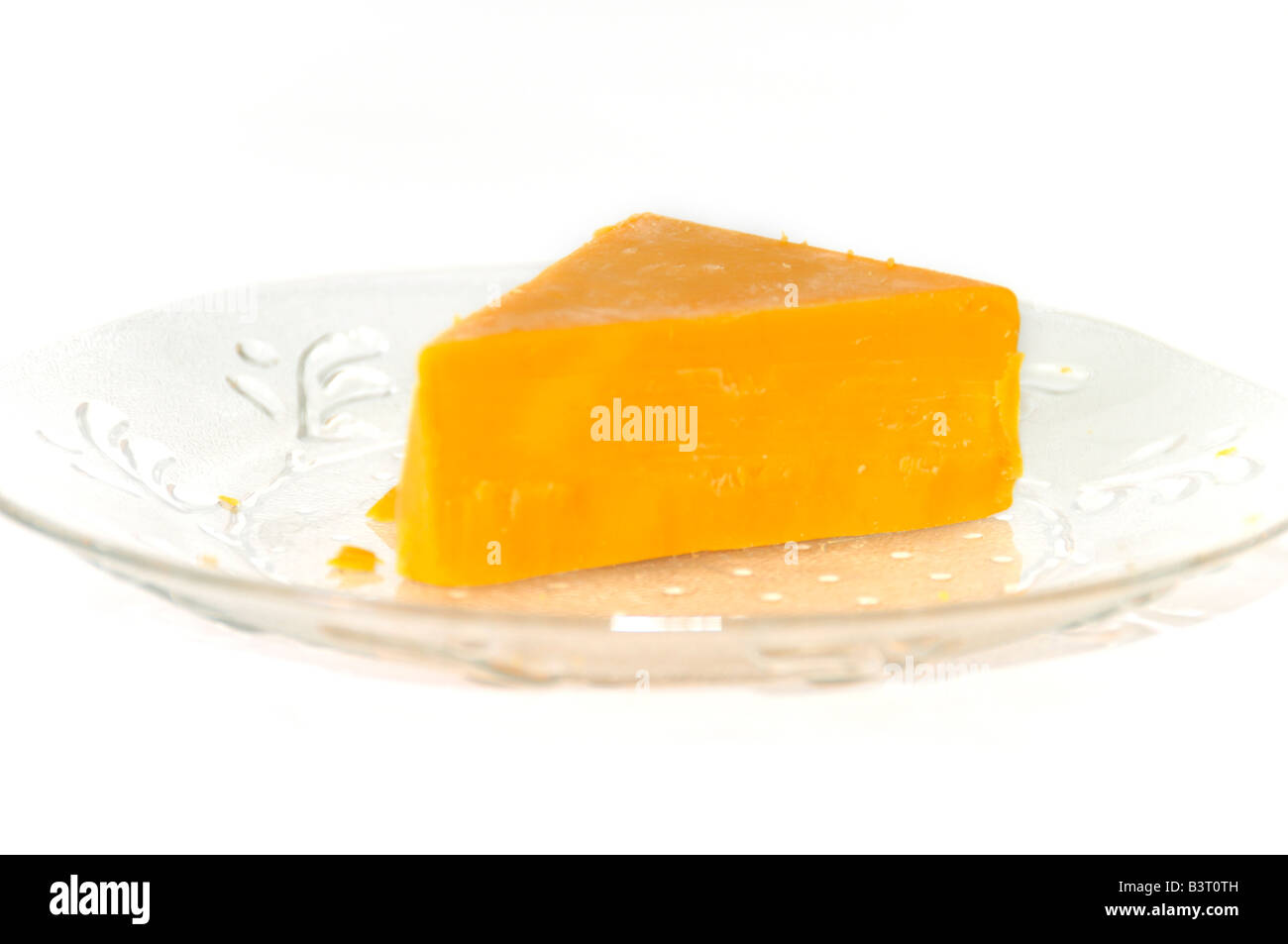 A wedge of cheddar cheese on a clear plate Stock Photo - Alamy
