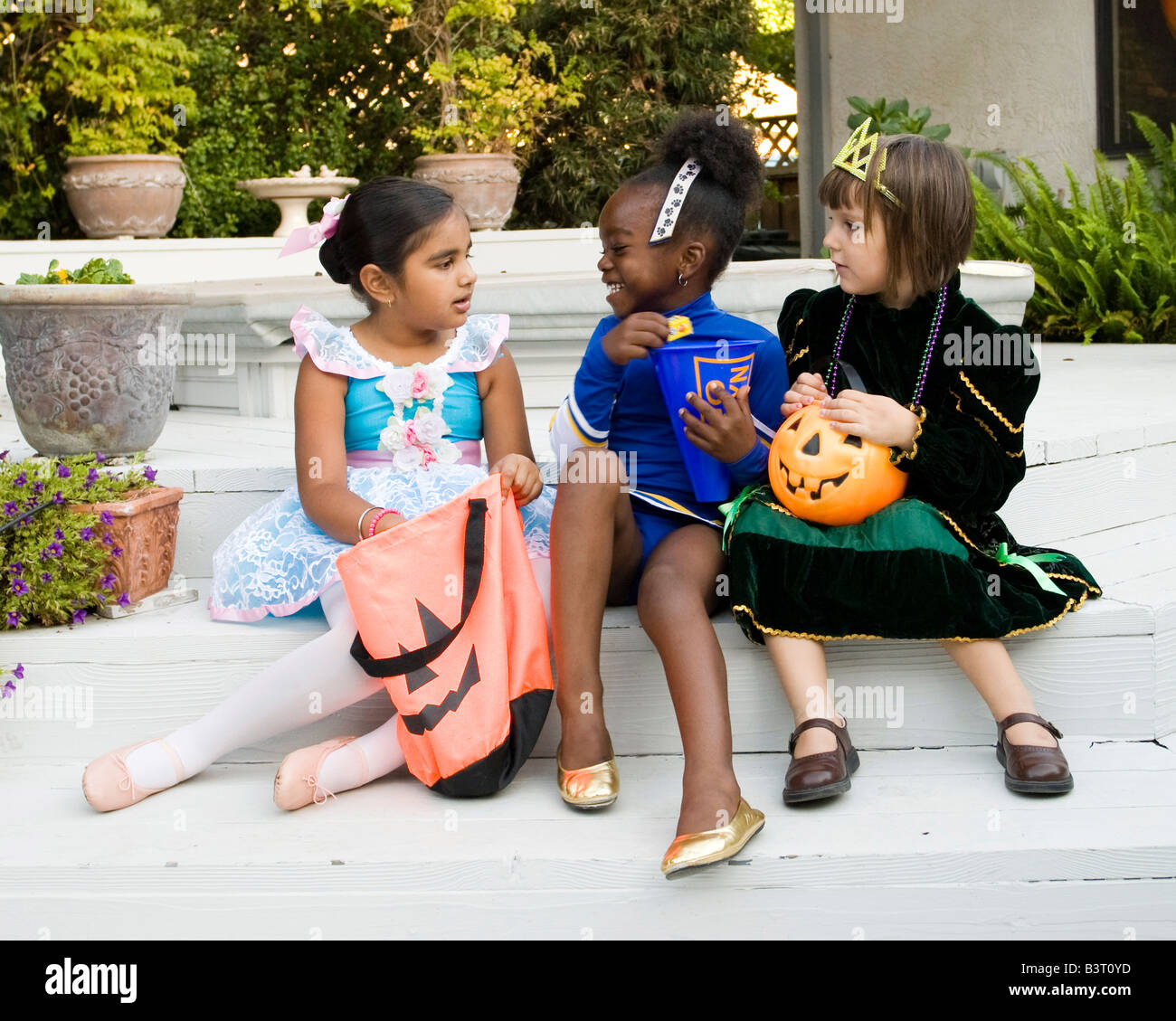 Little girls dressed as a ballerina and princess check their Halloween ...