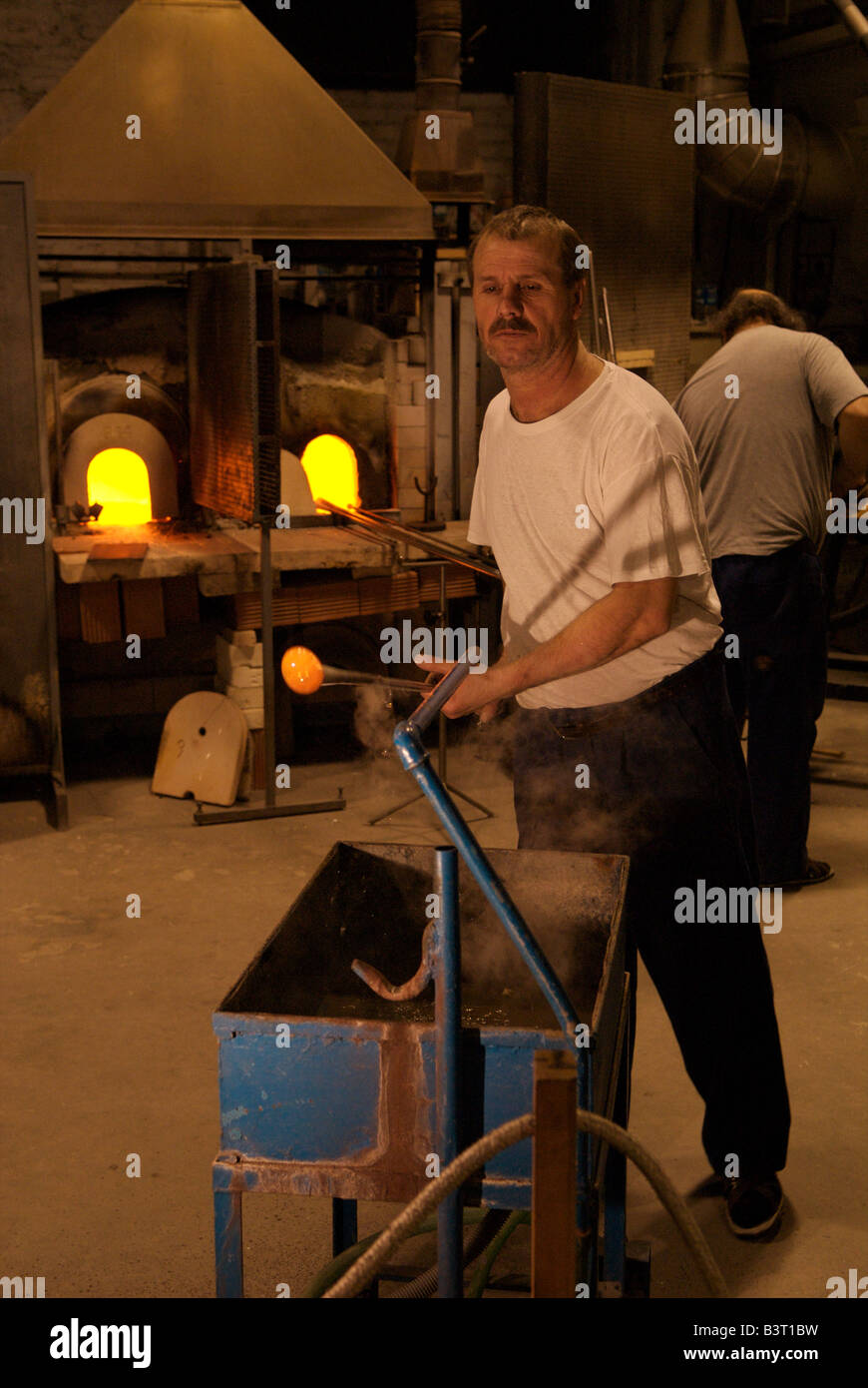 Venetian glass blower working a piece of glass in Murano near Venice ...