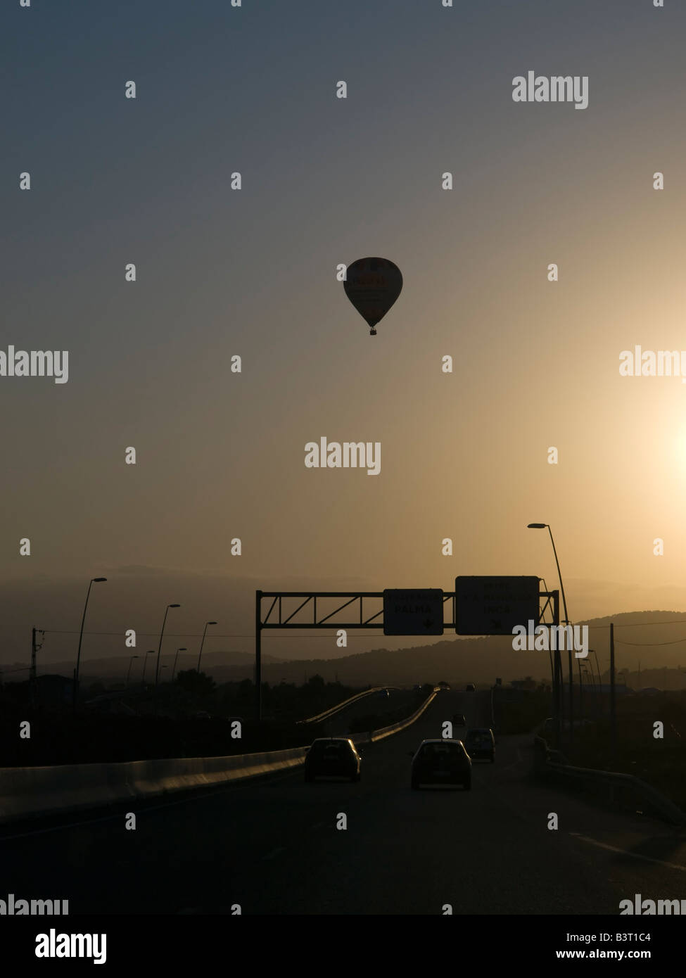 Hot air balloon in sunset over road Stock Photo - Alamy