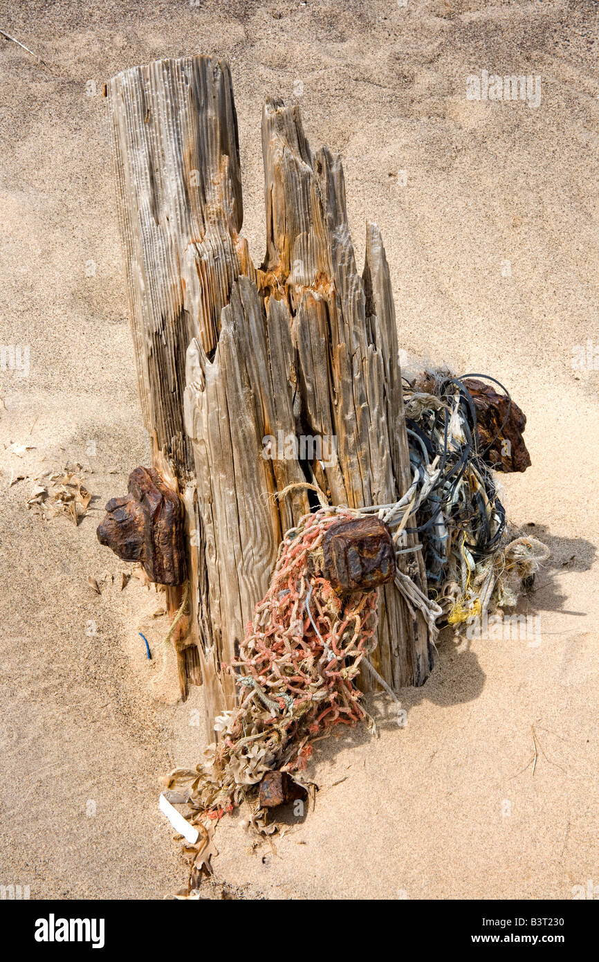Old post tangled in net on sand Stock Photo - Alamy