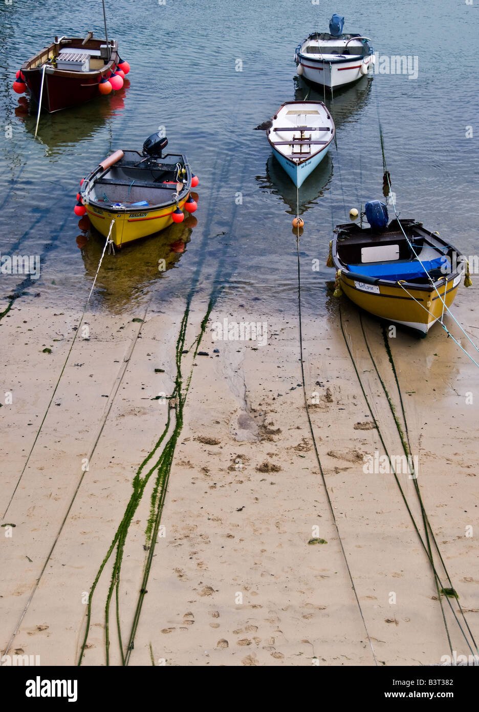 Five boats moored in Mousehole harbour Stock Photo - Alamy