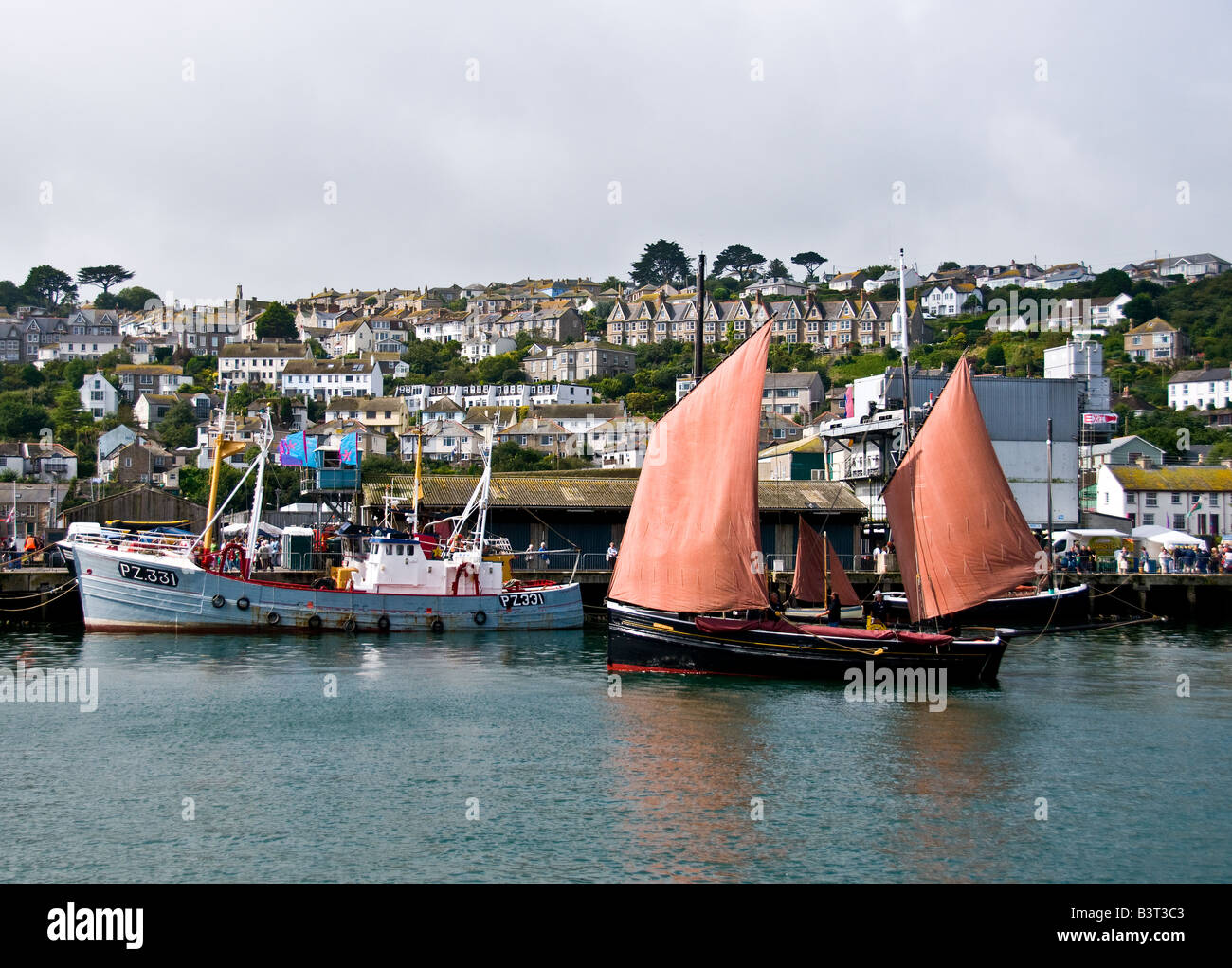 A traditional lugger sailing past a modern fishing vessel in Newlyn ...