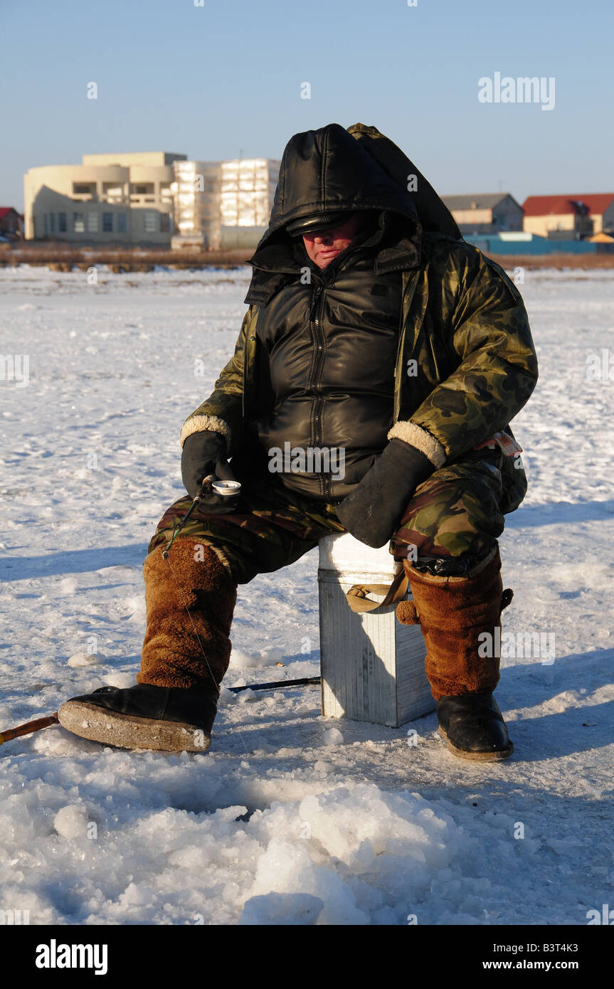 Winter fishermen enjoy the minus 25 degrees on the river Ural Stock ...