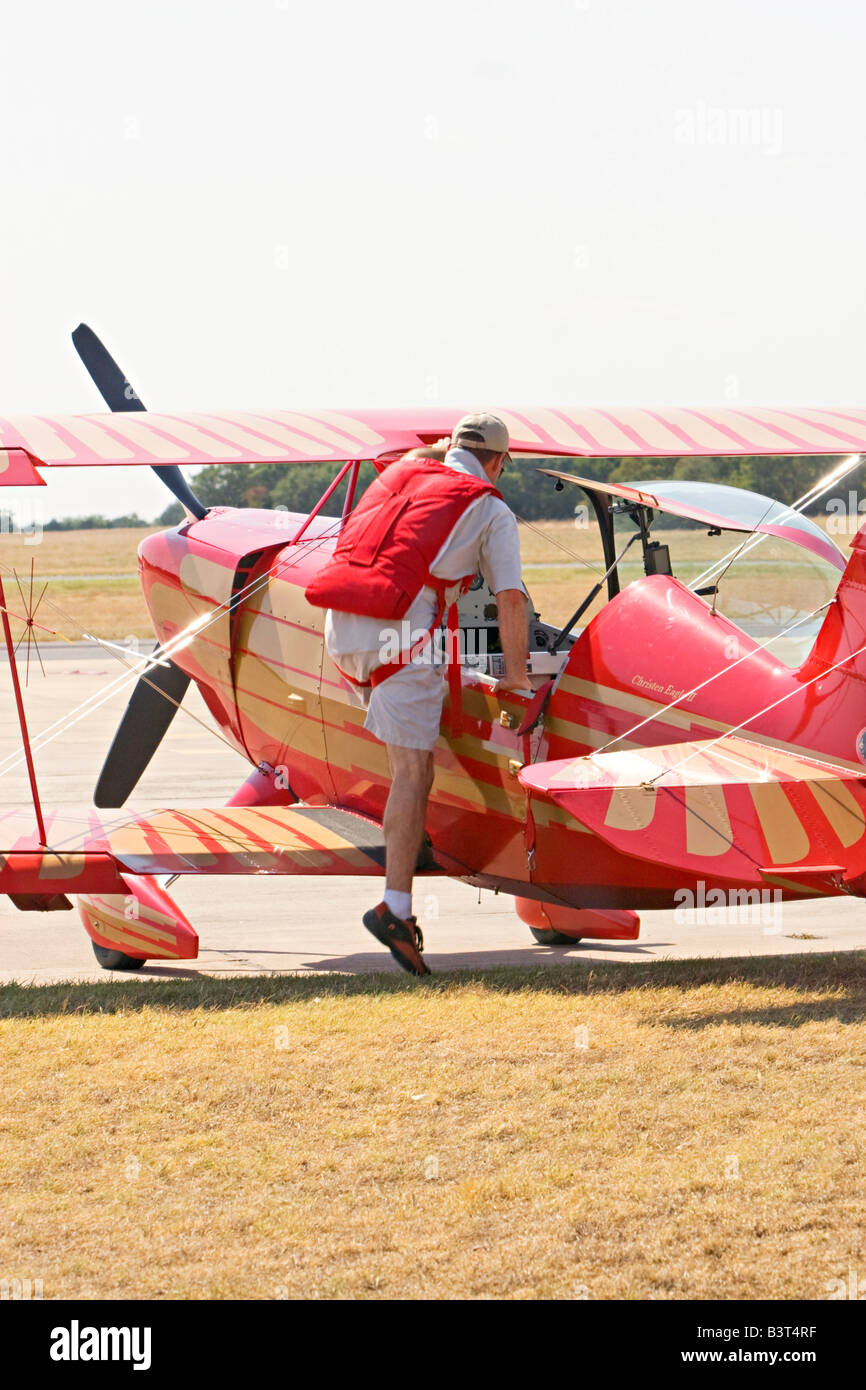 Pilot climbing into aerobatic biplane airplane cockpit Stock Photo - Alamy