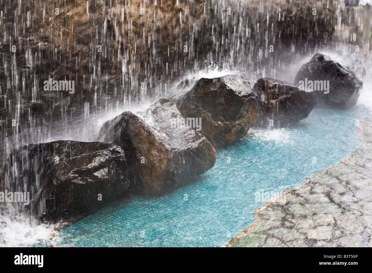 Rocks under waterfall Stock Photo - Alamy