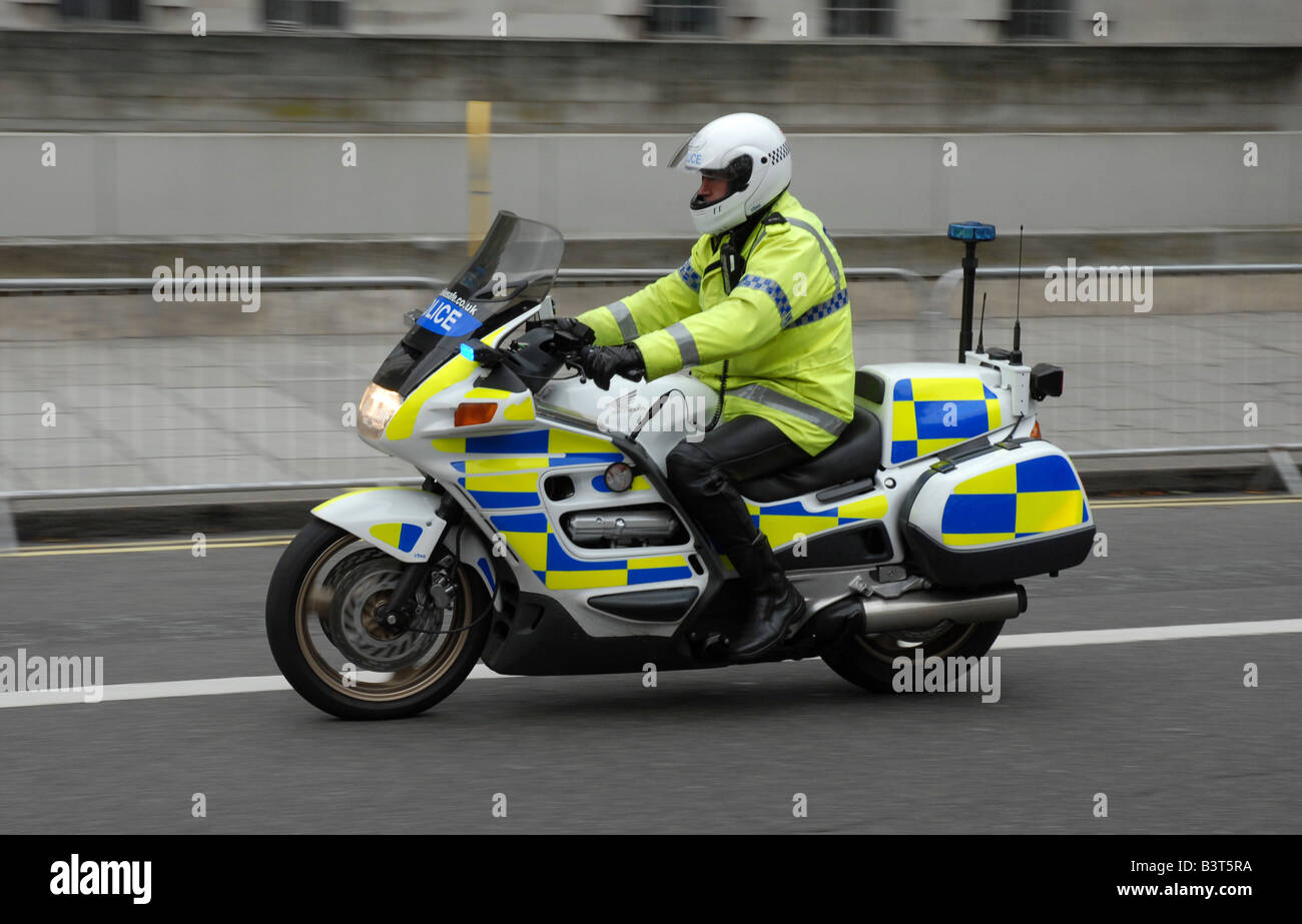 A Police motorcyclist speeds along Whitehall in Central London England ...