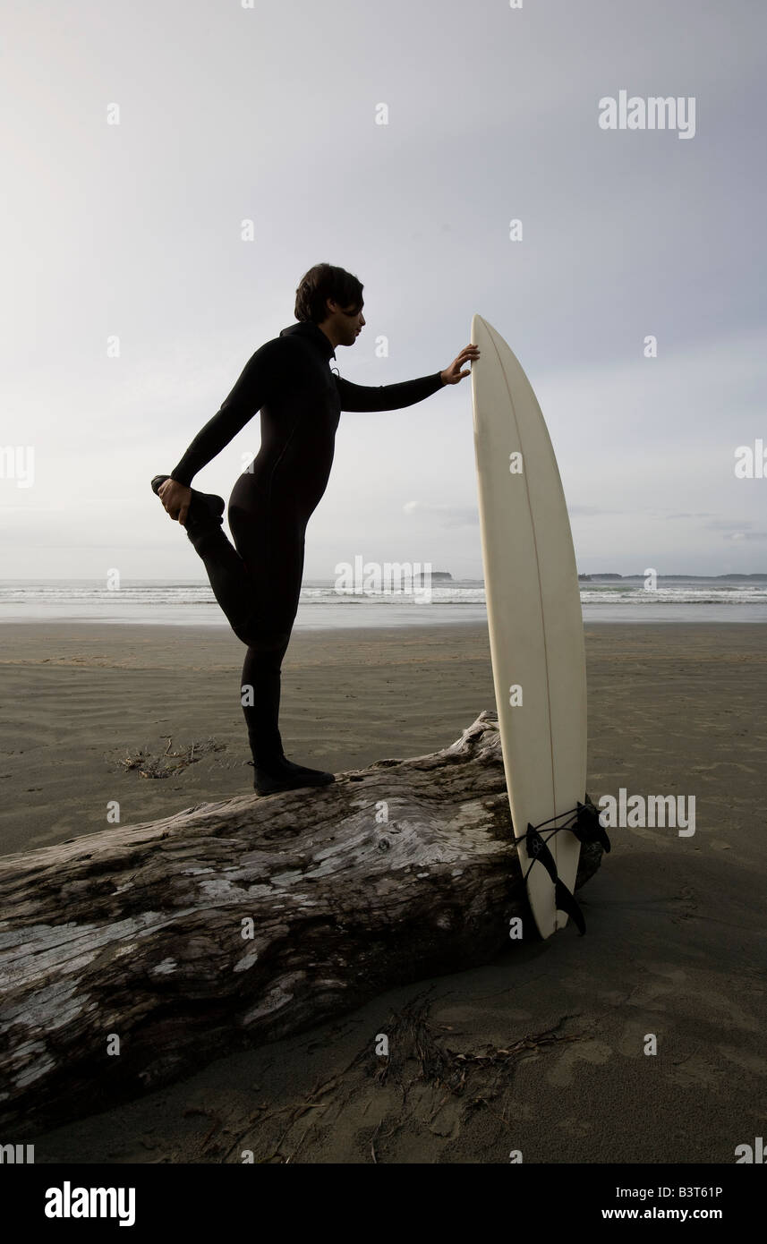 Surfer stretching on beach Stock Photo - Alamy