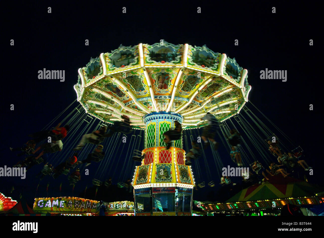 People riding the Wave Swinger Tilt a Whirl at a County Fair Stock ...