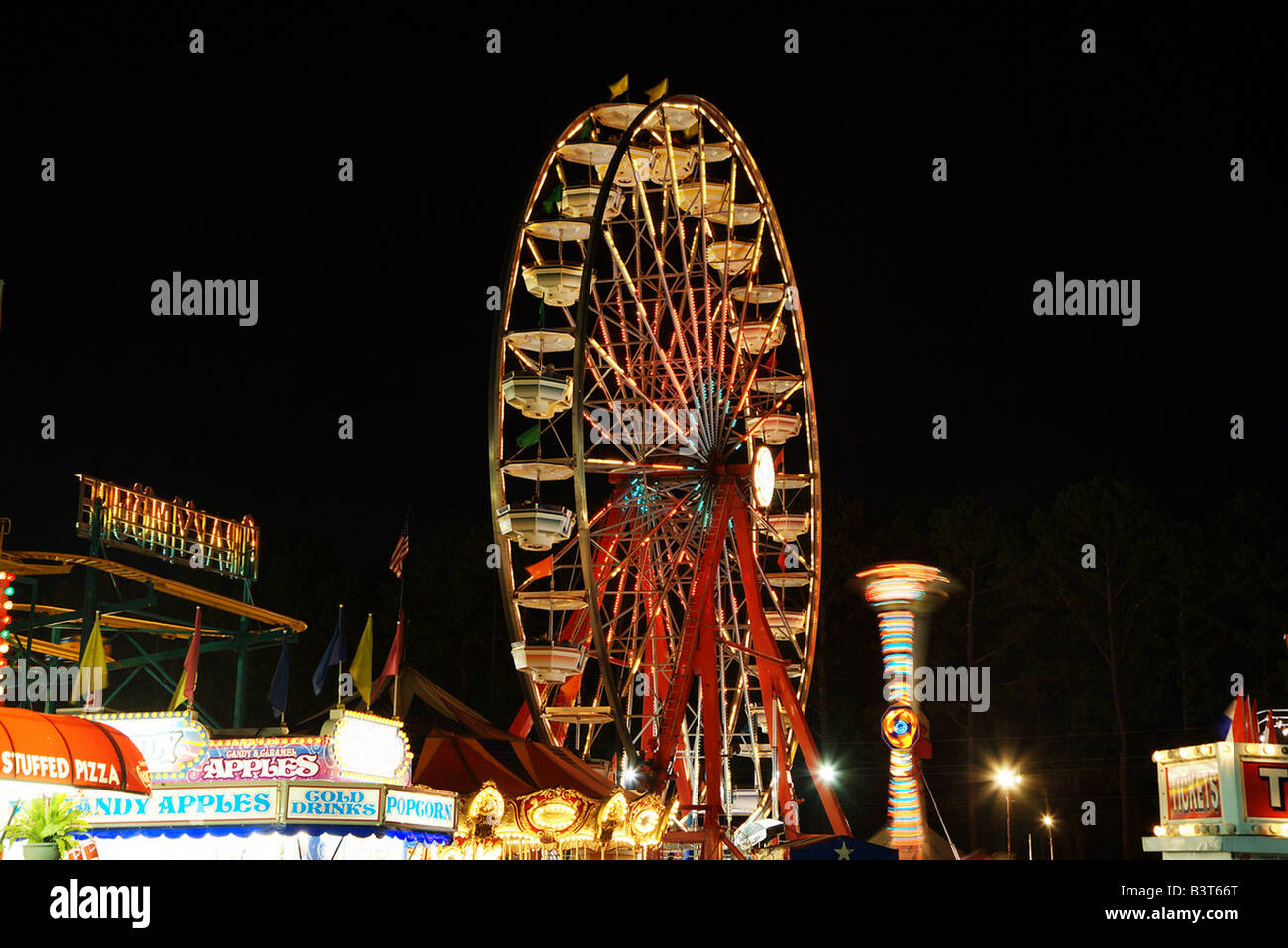 A ferris wheel lit brightly during night time activities at a County ...