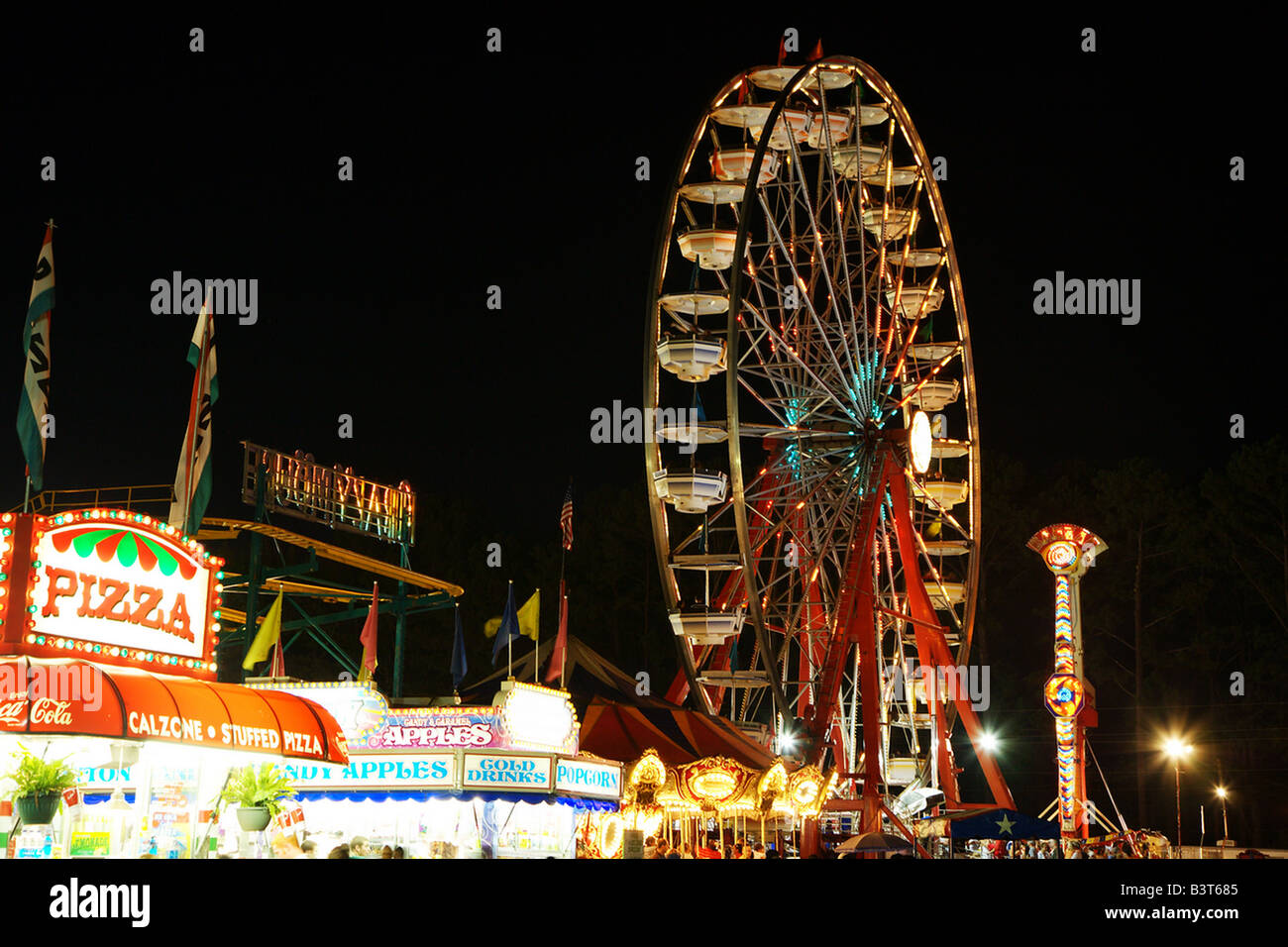 A ferris wheel lit brightly during night time activities at a County ...