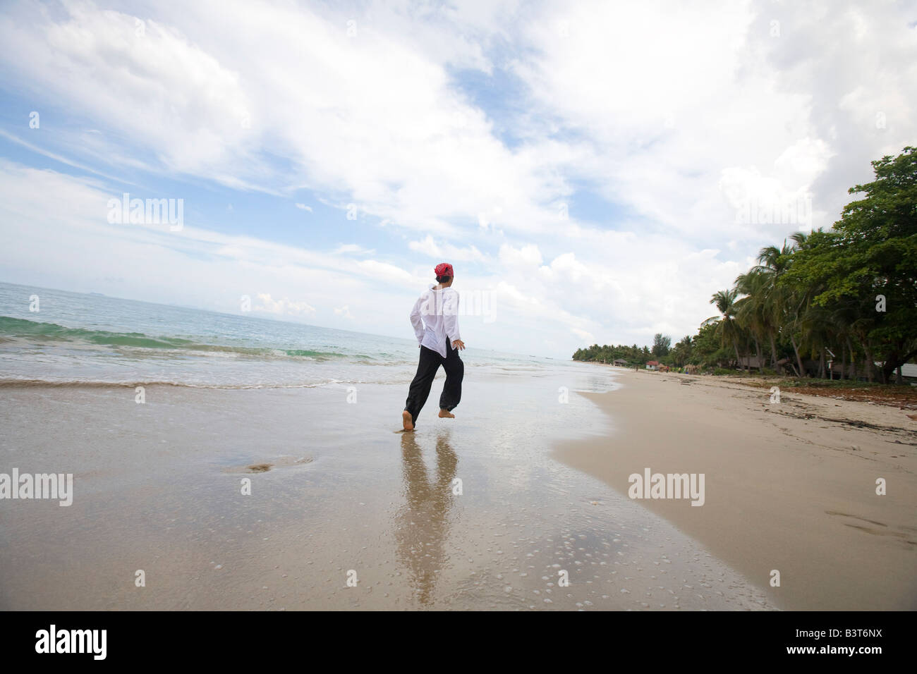 A man running along the beach Stock Photo - Alamy