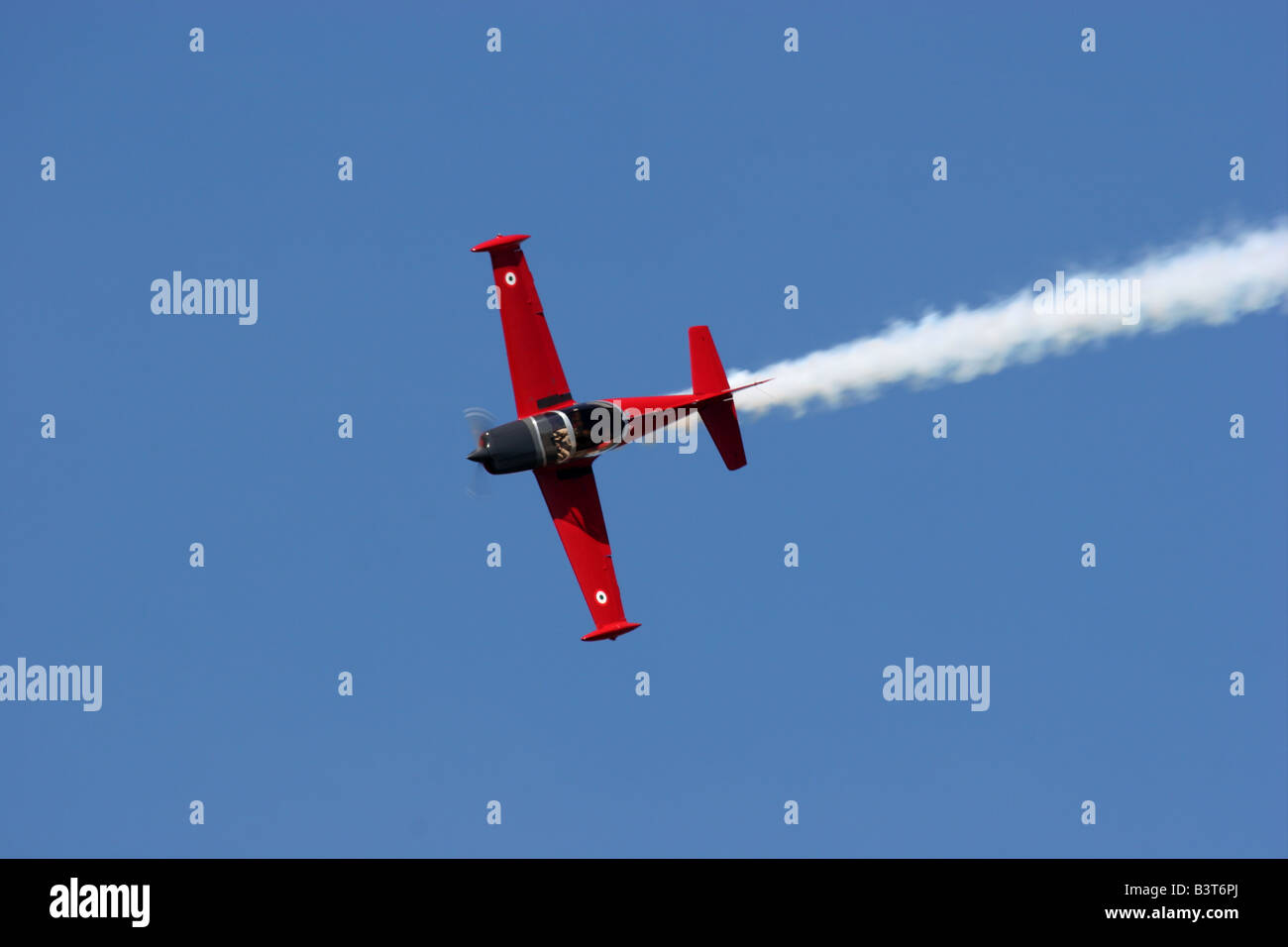 A red airplane with smoke on Stock Photo - Alamy