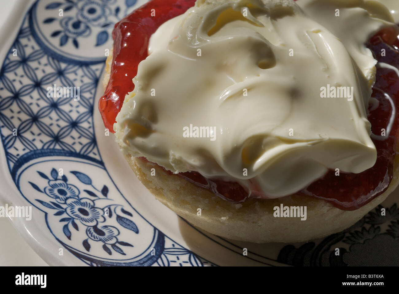 Cornish cream tea scone with jam and clotted cream, on blue and white ...