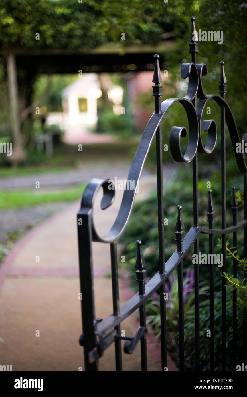 Iron gateway leading into a beautiful garden courtyard with ivy trellis ...