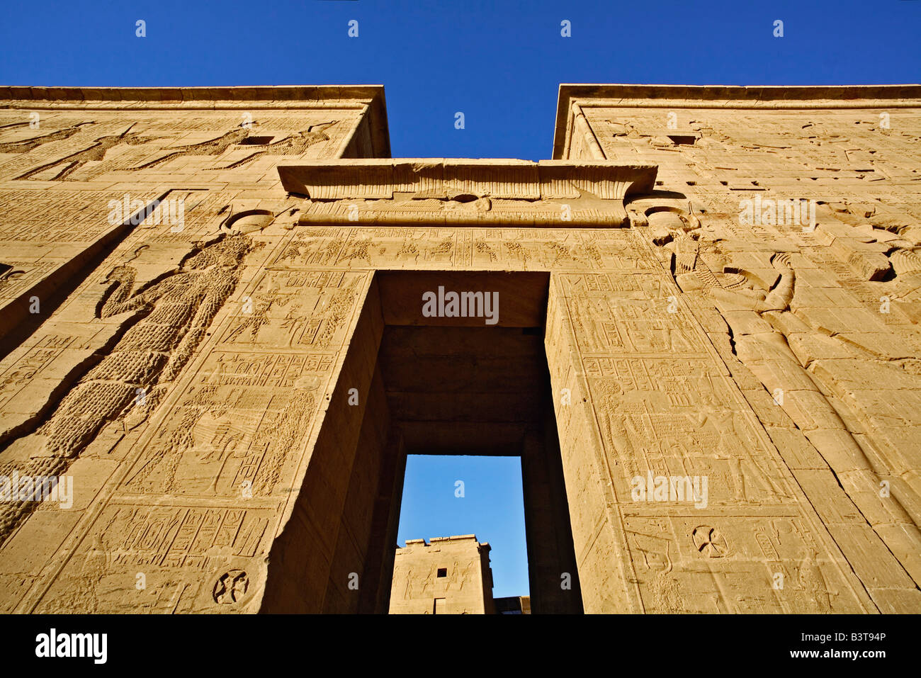 Skyward view of entry pylons and giant figures, Temple of Philae, on ...