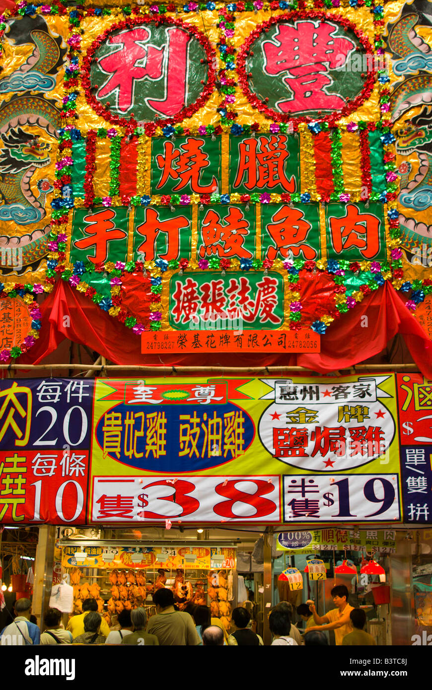 Asia, China, Hong Kong. Shoppers buy seafood and meat at a storefront ...