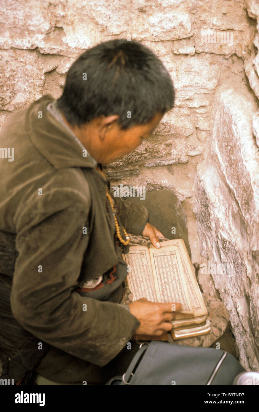Tibet, Lhasa. Pilgrim reading buddhist scriptures Stock Photo - Alamy
