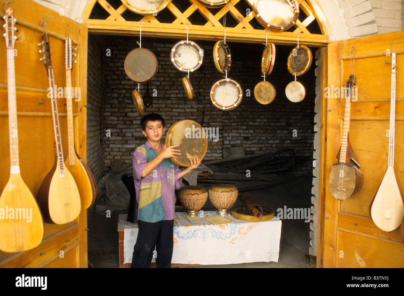 Young boy selling musical instruments in the Tashkent Market ...