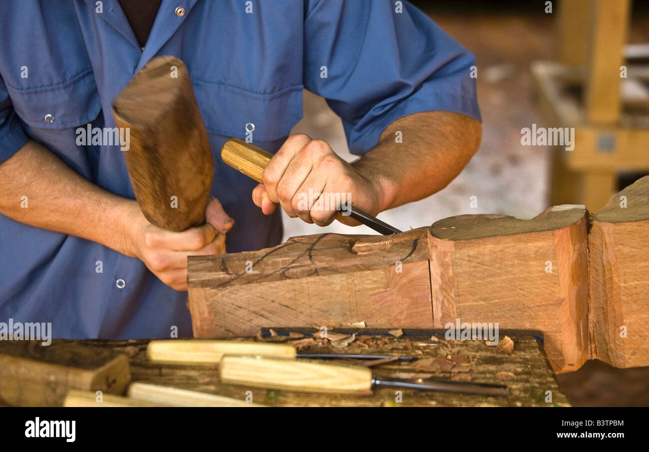 New Zealand, Rotorua. Wood carver at work making traditional Maori wood ...